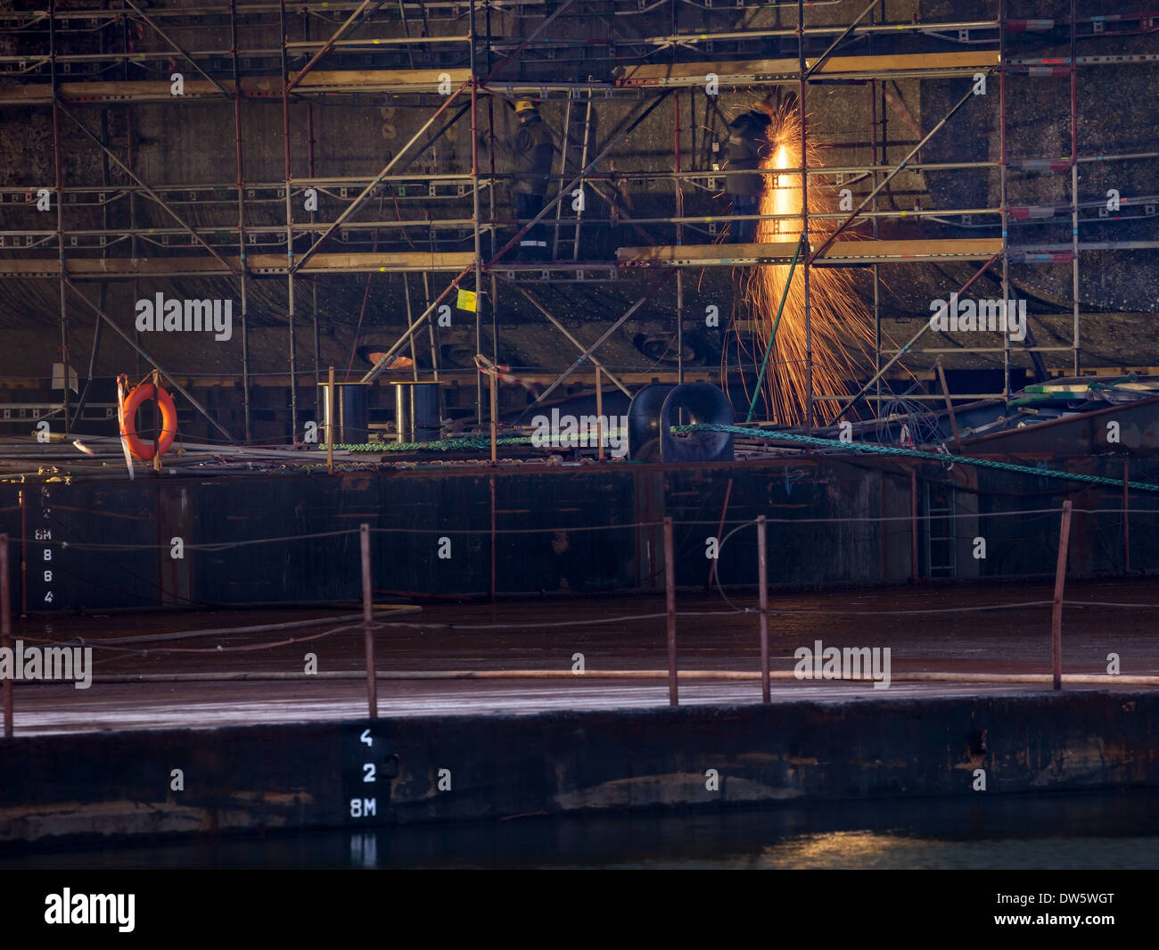 A shipyard steel worker burning steel on scaffolding Stock Photo - Alamy