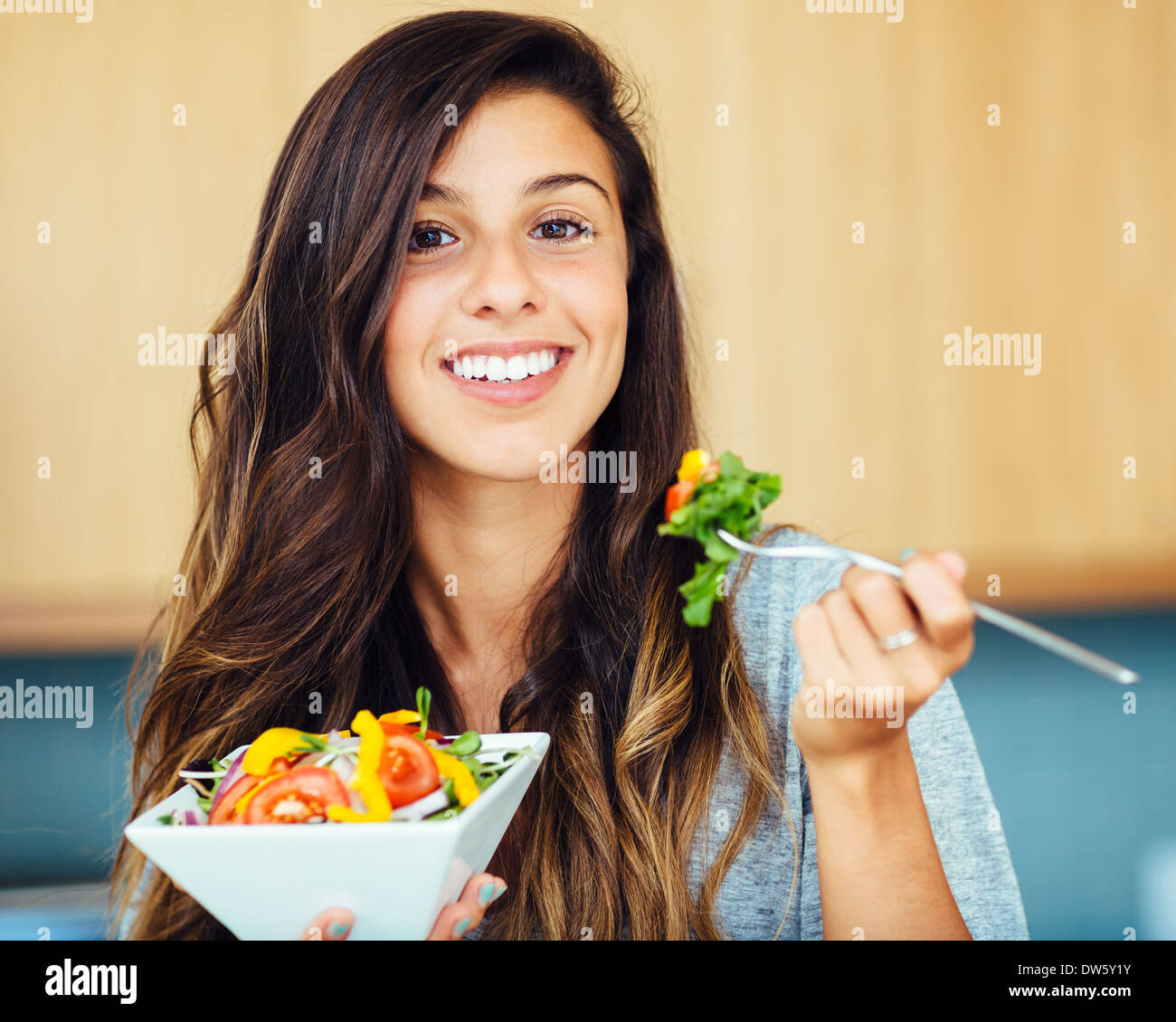Attractive young woman eating salad Stock Photo - Alamy