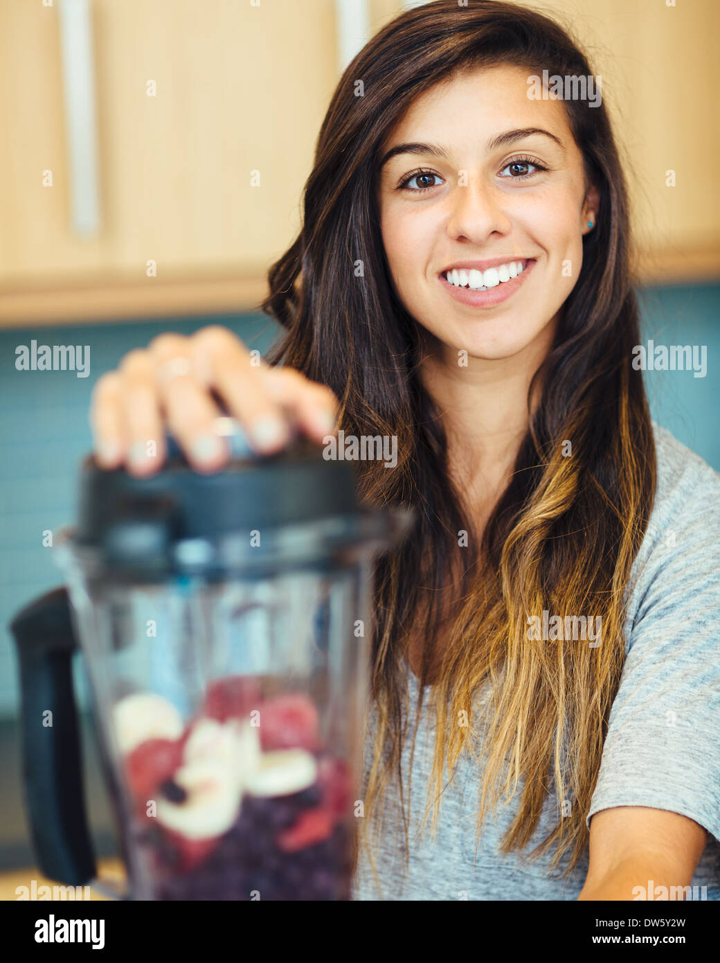 Beautiful Young Woman Making Fruit smoothie Stock Photo - Alamy