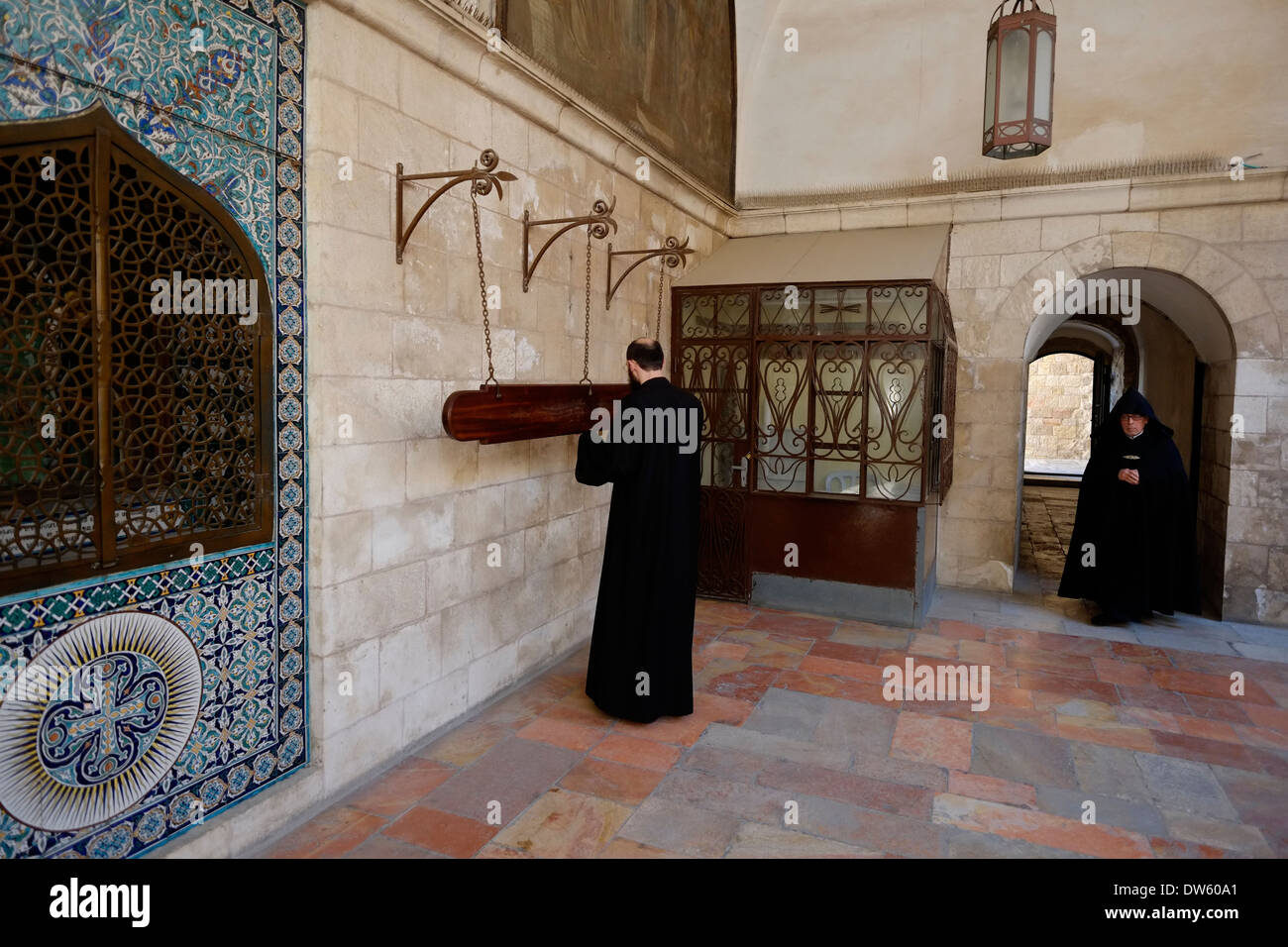 Armenian priest using a wooden "Nakos" which is the Arabic name of the ...