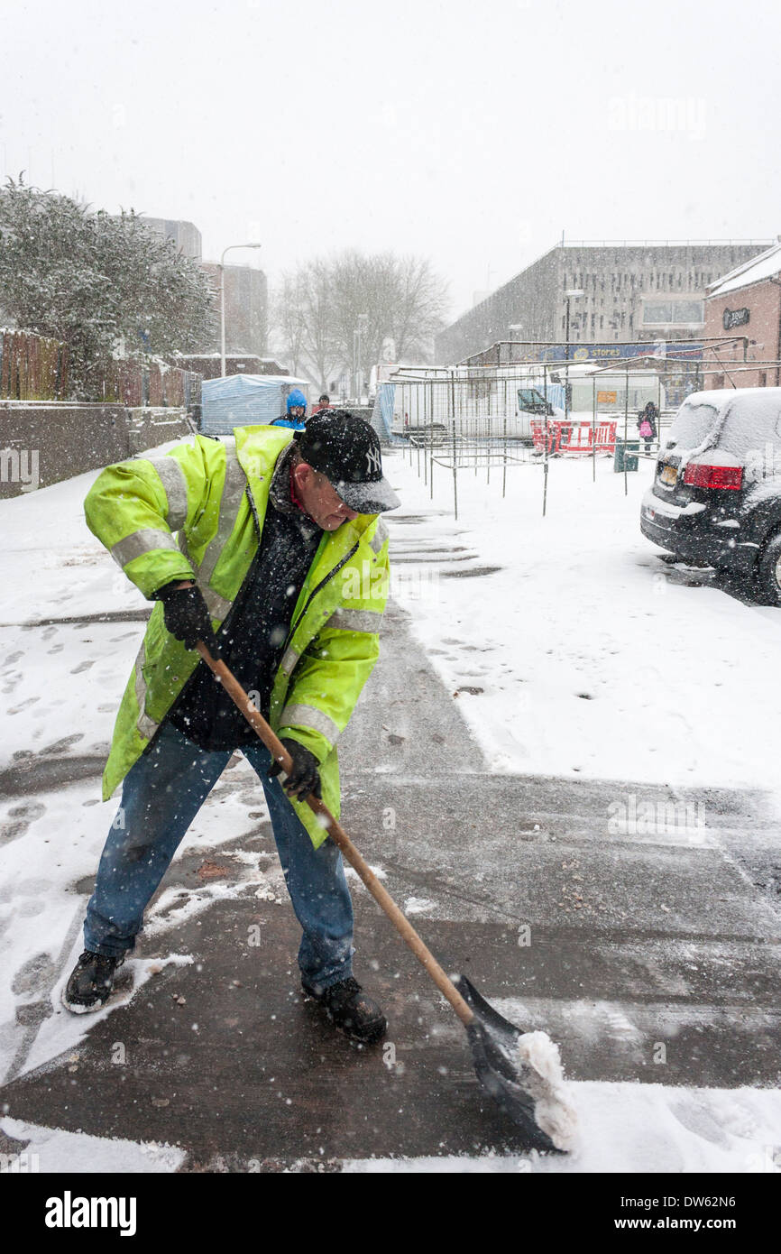 Council worker clears icy paths in snow blizzard. Reading, Berkshire ...