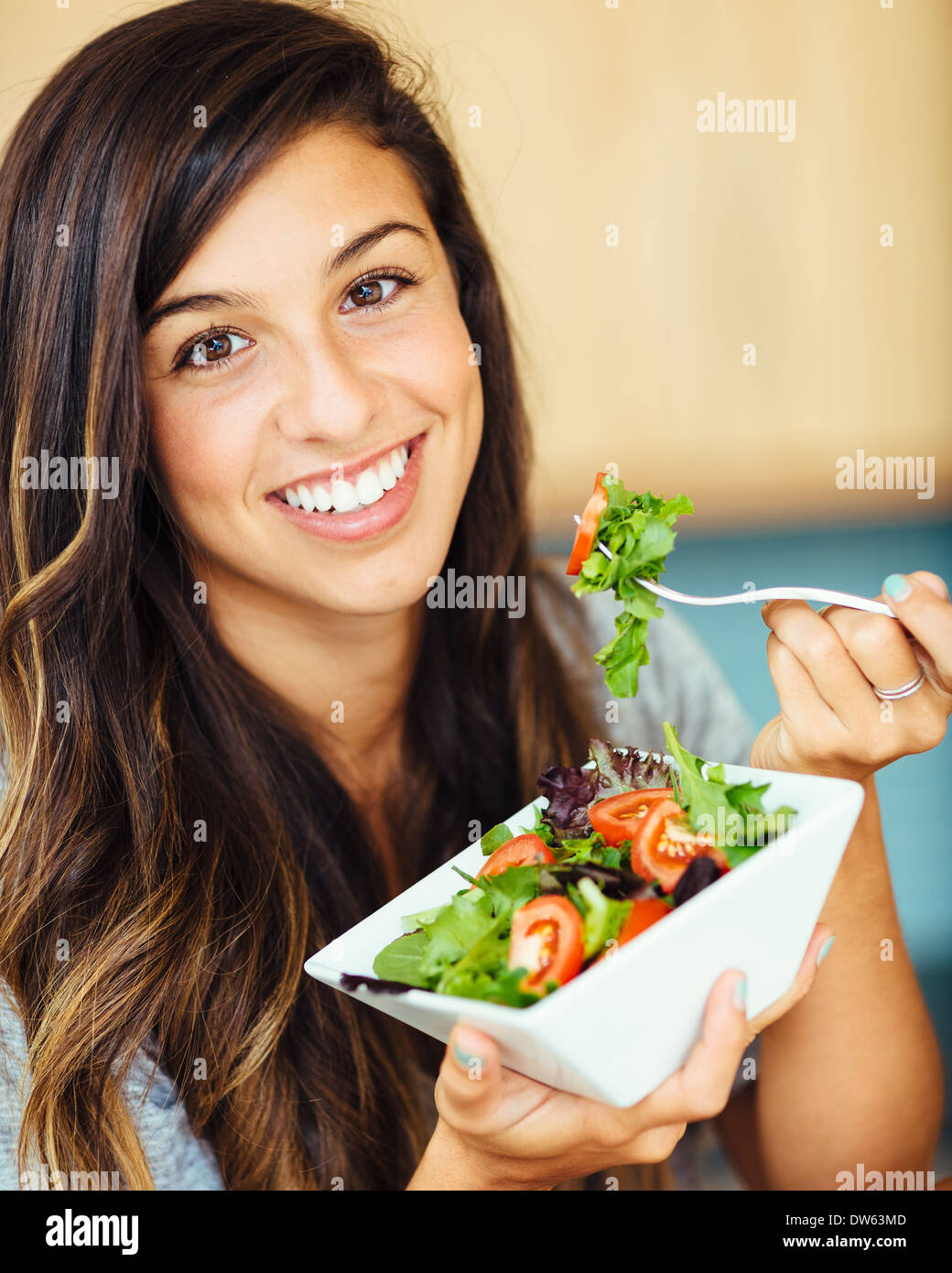 Attractive young woman eating salad Stock Photo - Alamy