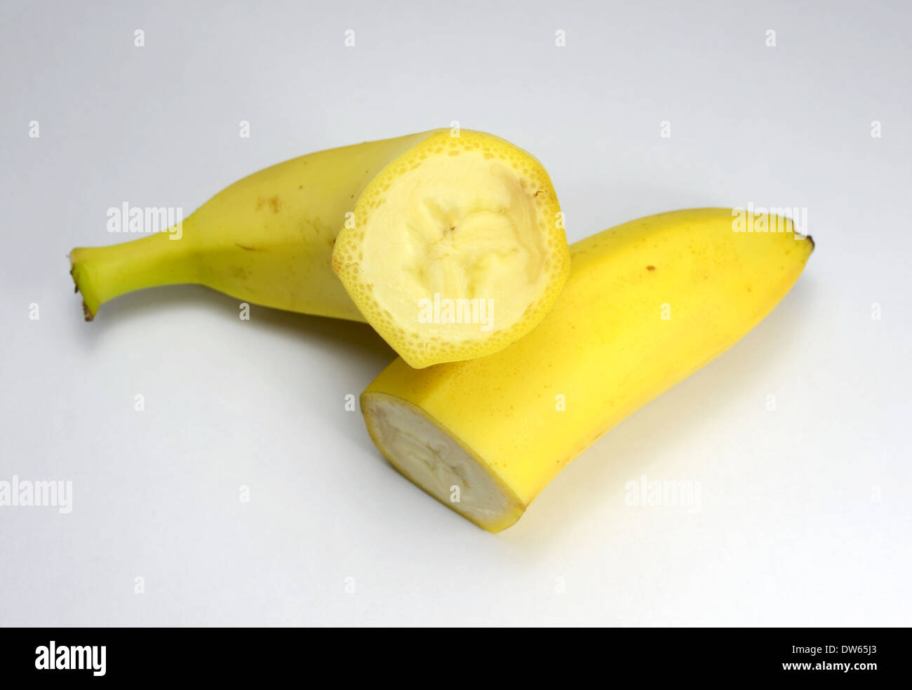 Banana cut into 2 pieces isolated on white background Stock Photo - Alamy