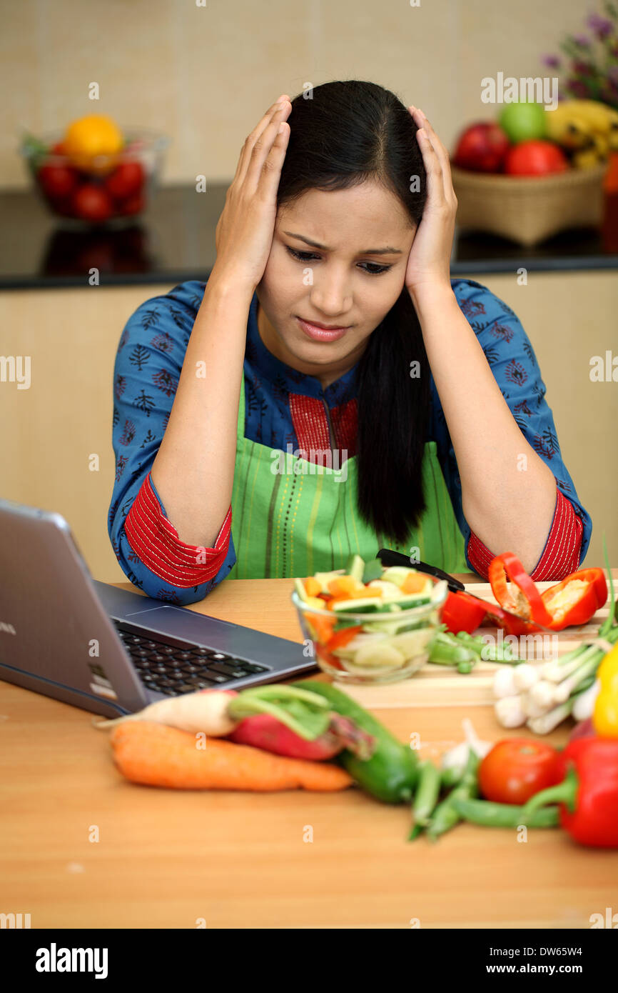 Stressed young woman in kitchen Stock Photo - Alamy