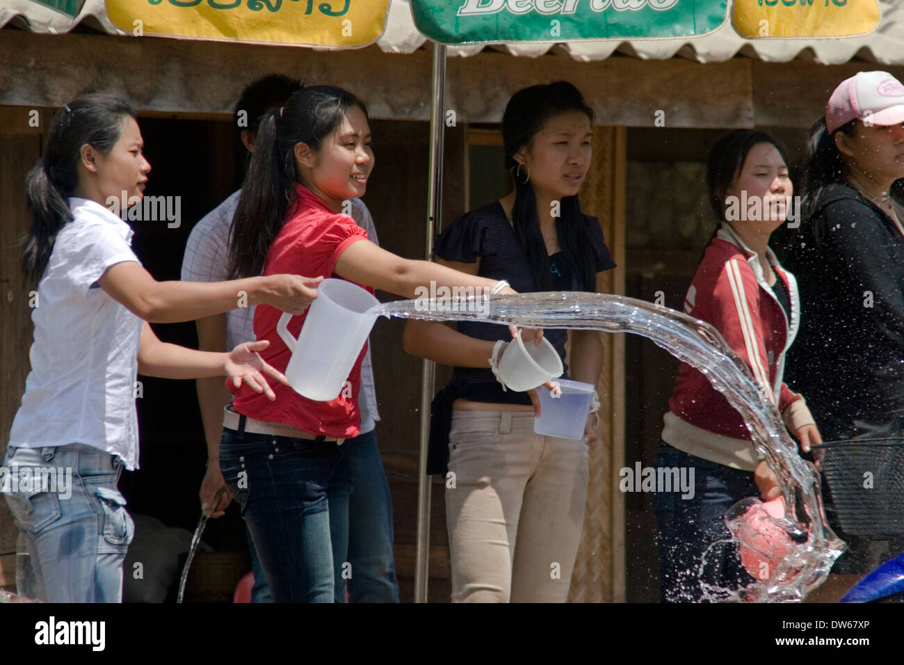 A group of women are throwing water at passersby on a city street ...