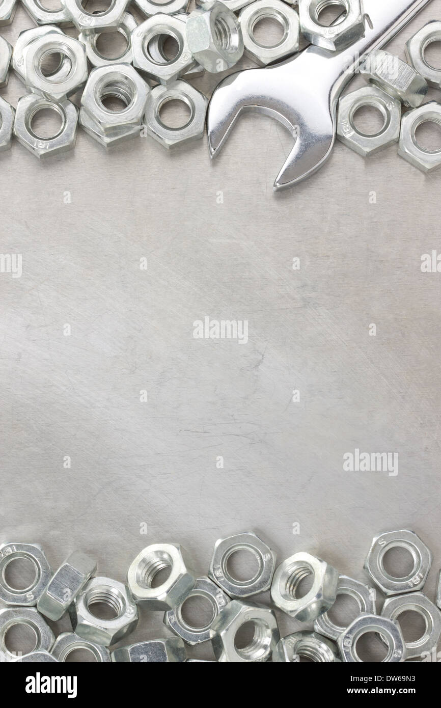 wrench and nut tool on metal background texture Stock Photo - Alamy