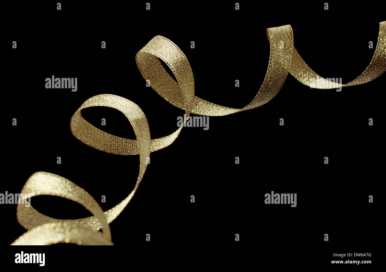 Gold ribbon ribbon on black background Stock Photo - Alamy