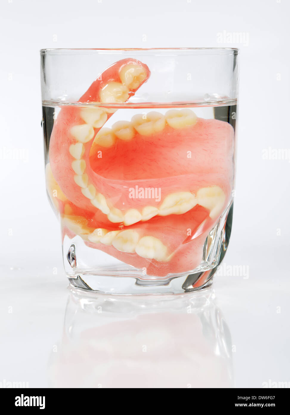 A set of dentures in a glass of water on a white background Stock Photo ...