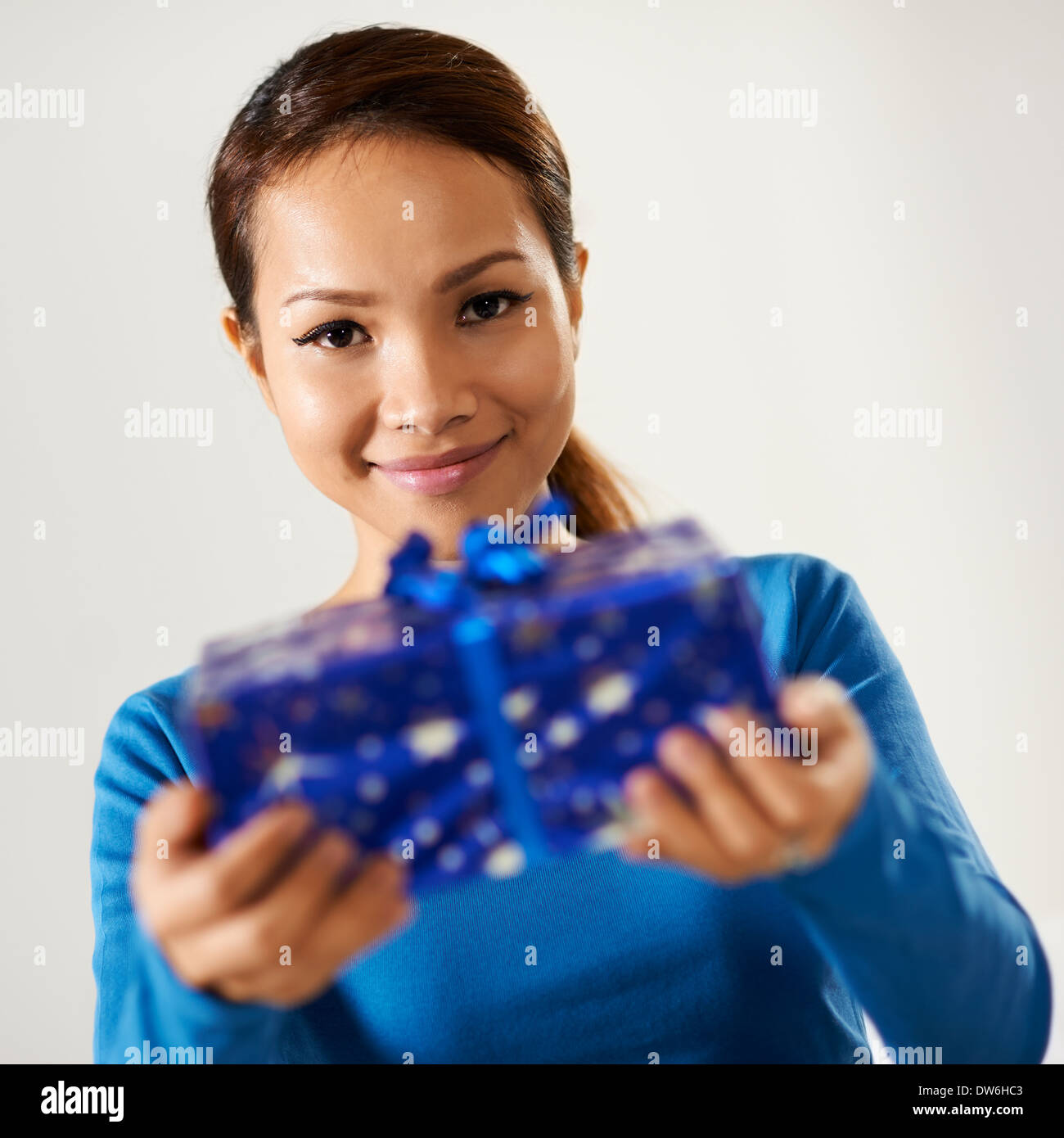 asian woman showing present to the camera and smiling Stock Photo - Alamy