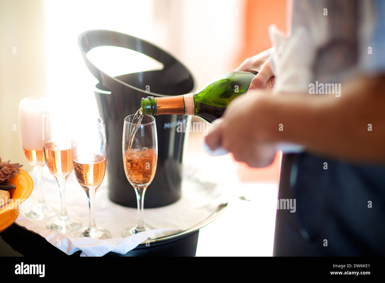 Waiter pouring the perfect glass of pink champagne at a wedding ...