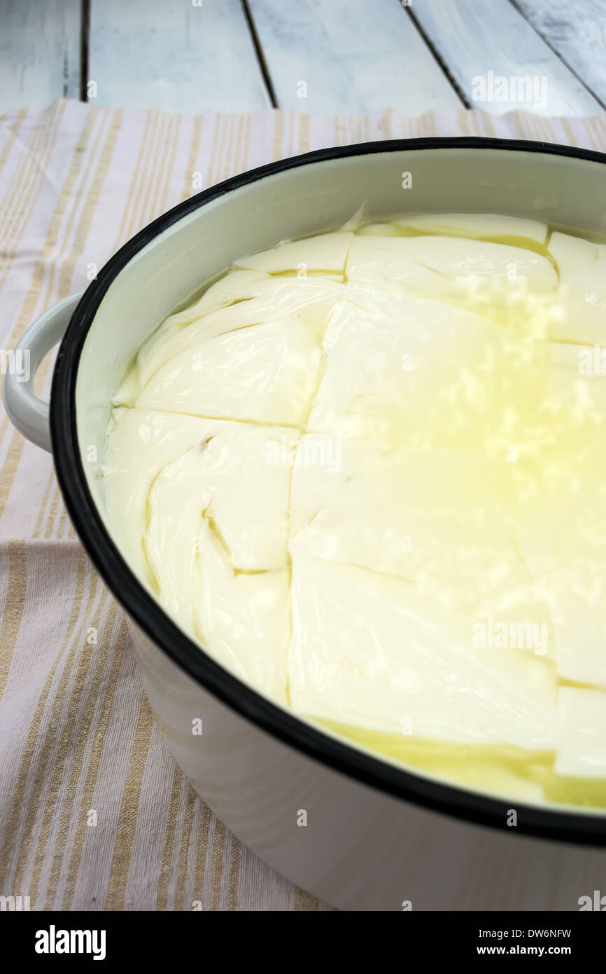 Fresh homemade white cheese in a container with brine Stock Photo - Alamy