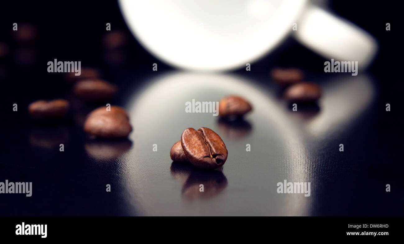 coffee beans on dark table with cup reflection Stock Photo - Alamy