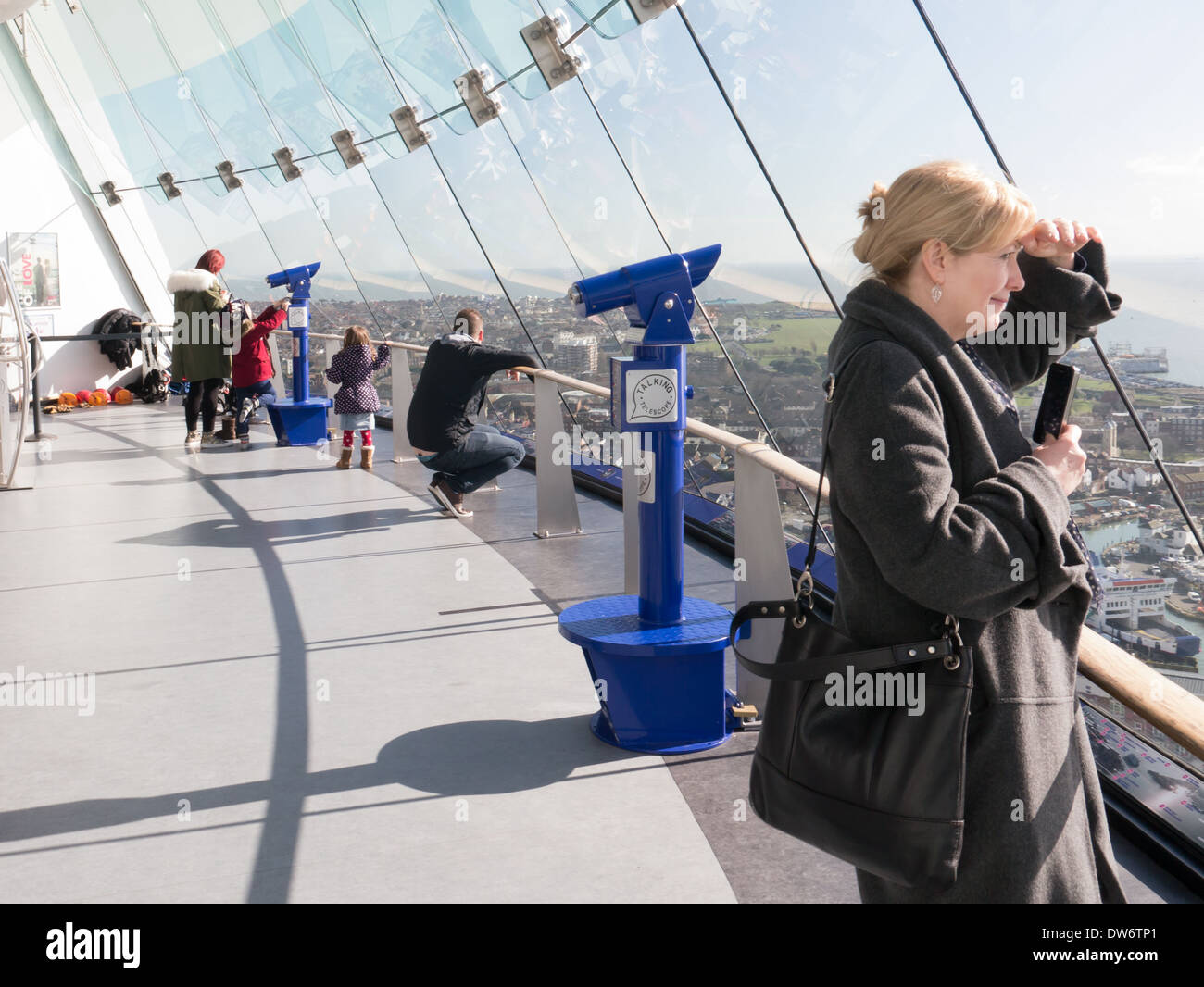 Tourists enjoy the view from the observation deck of the Spinnaker ...
