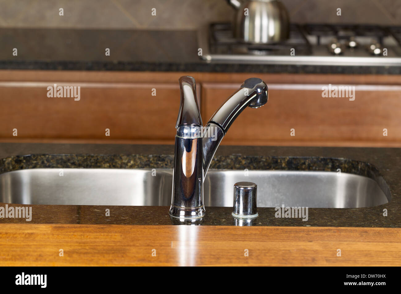 Horizontal photo of a chrome kitchen faucet with stone counter tops ...