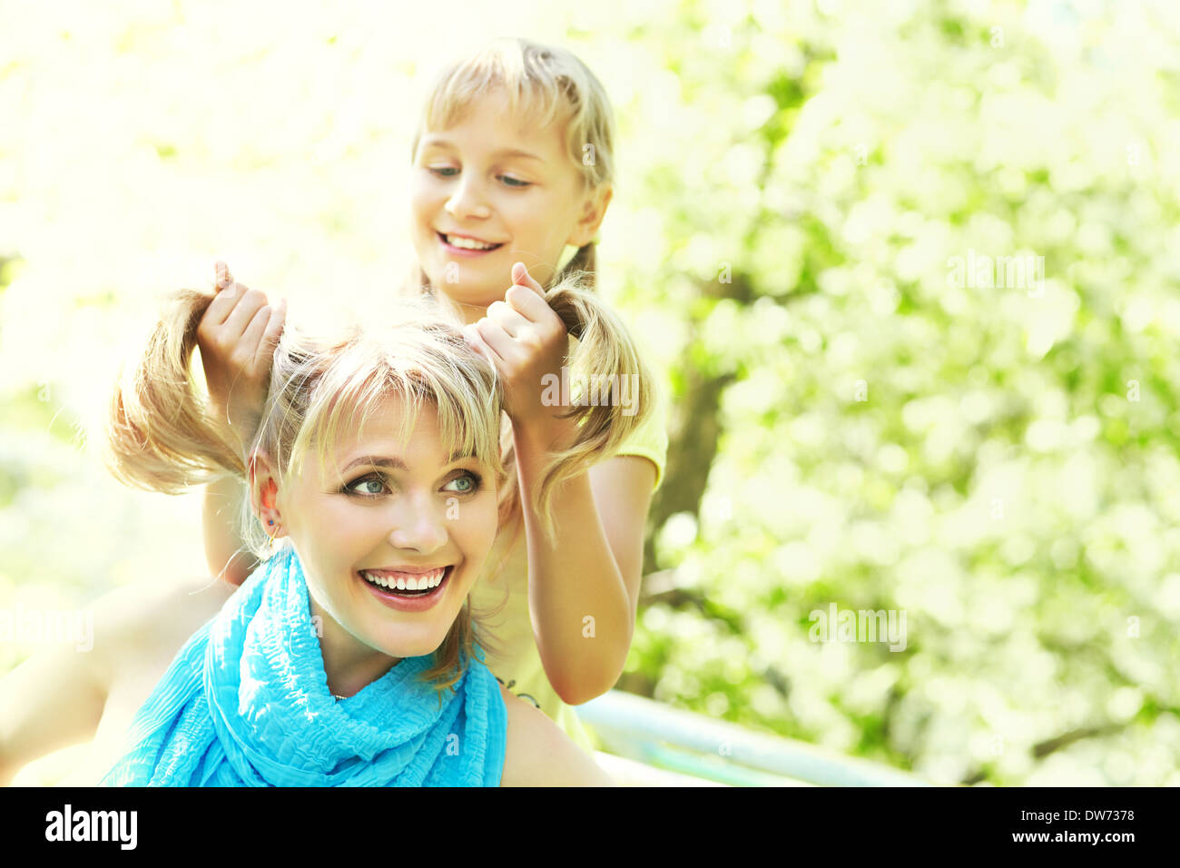 happy mother and daughter for a walk in the park on a light green ...