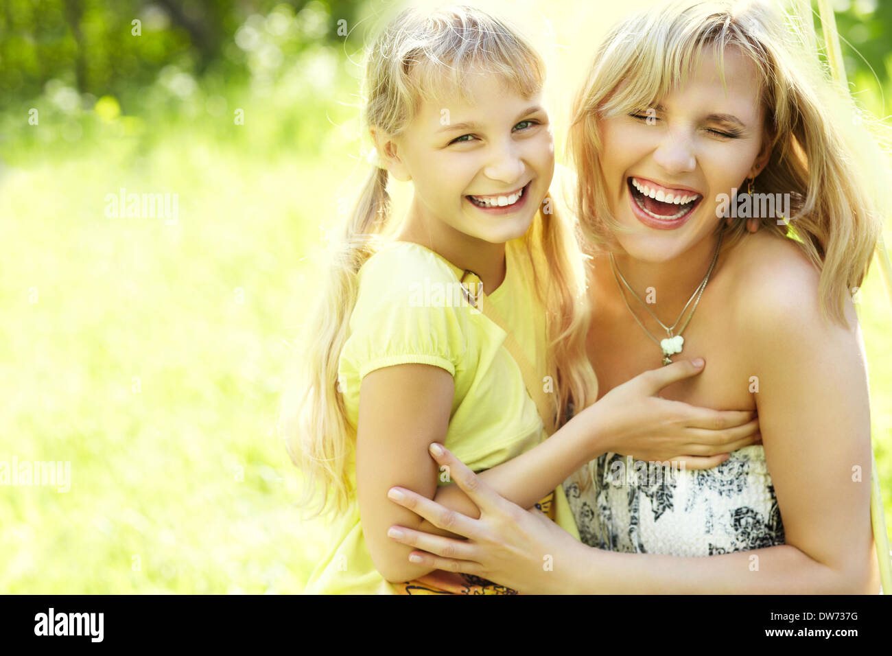 hugging happy mother and daughter for a walk in the park on a light green background Stock Photo ...