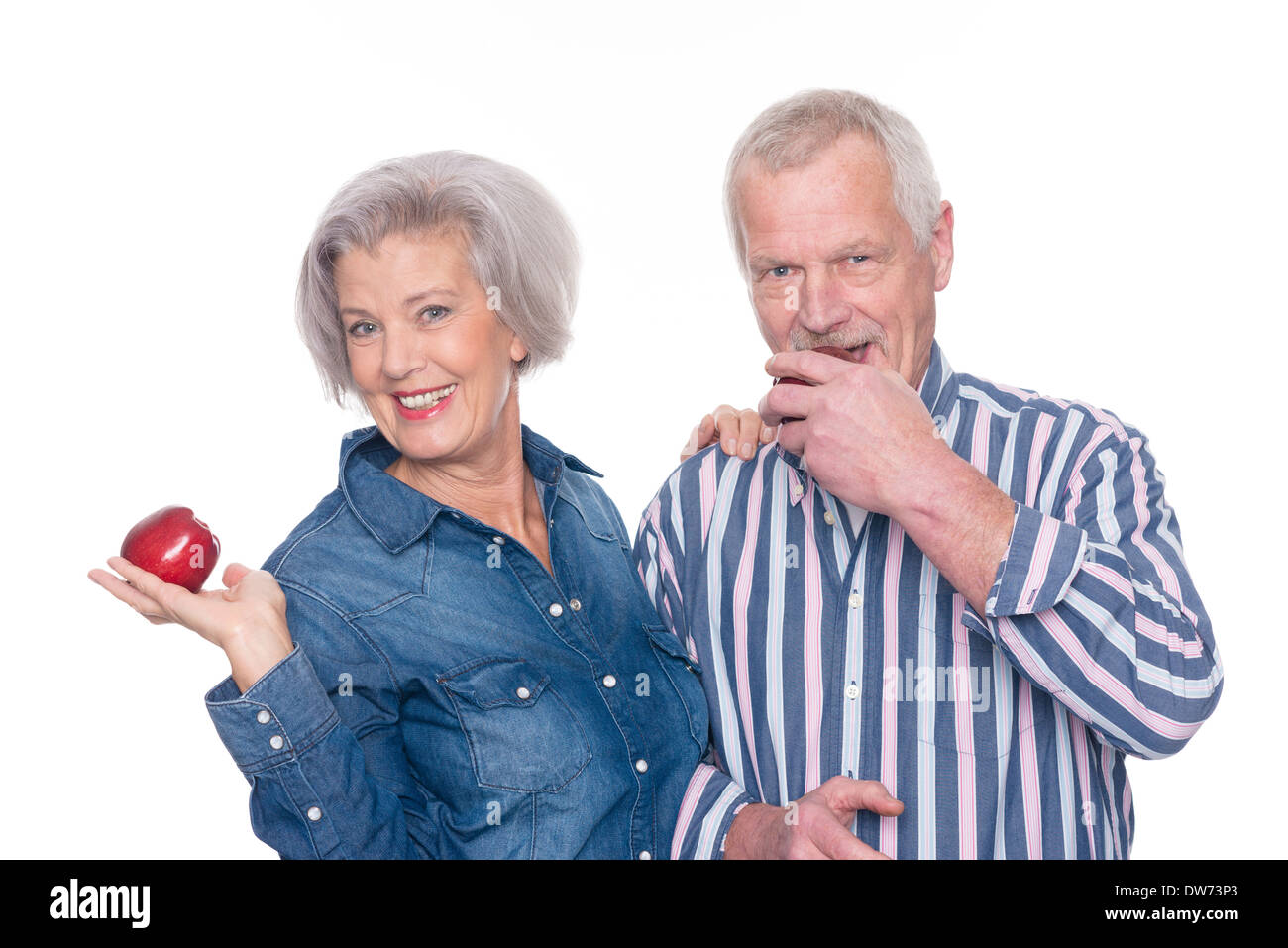 Senior couple with apple in front of white background Stock Photo - Alamy