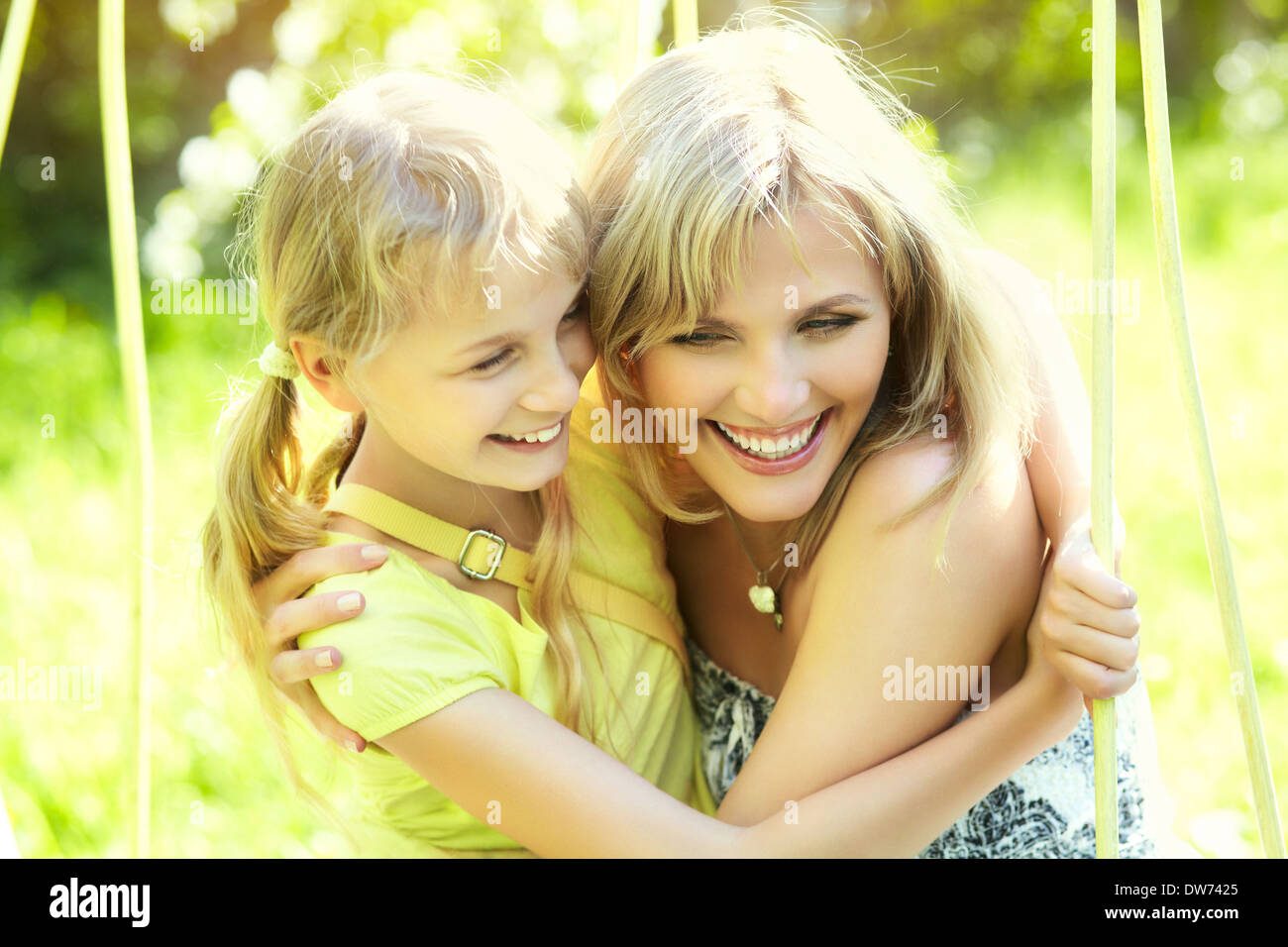 hugging happy mother and daughter for a walk in the park on a light green background Stock Photo ...