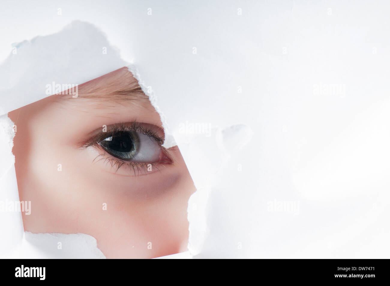 Child eye looking through a hole in paper Stock Photo - Alamy