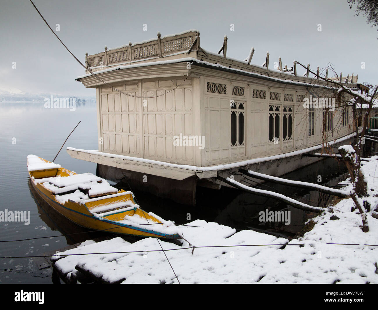 India, Kashmir, Srinagar, winter, snow clad houseboat and shikara ...