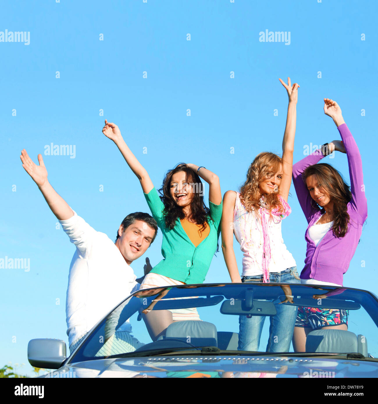 Happy friends dancing in cabriolet car Stock Photo - Alamy