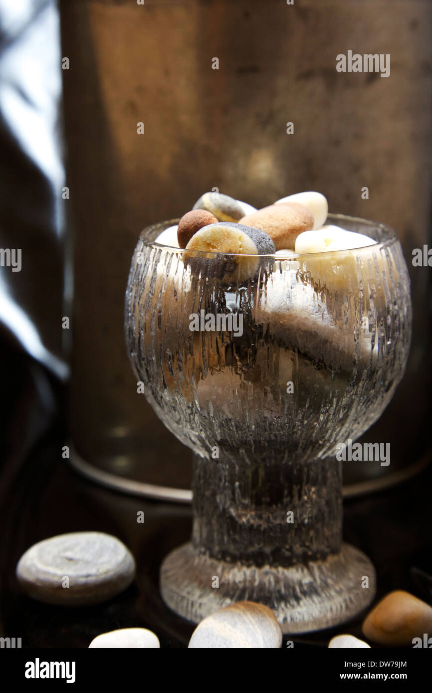 Decorative stones in a retro drinking glass with black surface and ...