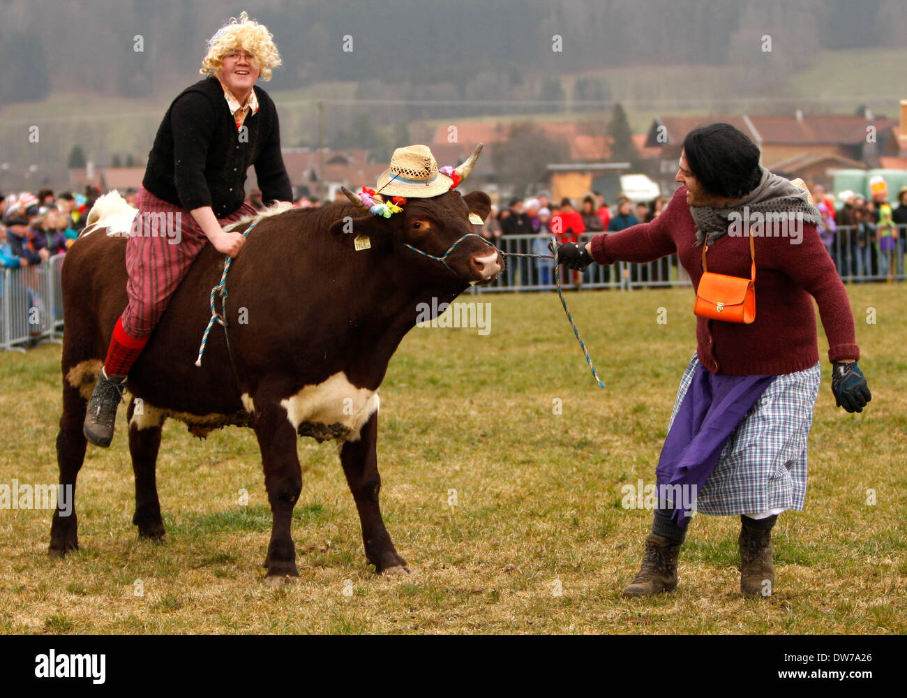 Masked riders and drovers lead their oxes to the race track in Rottau ...
