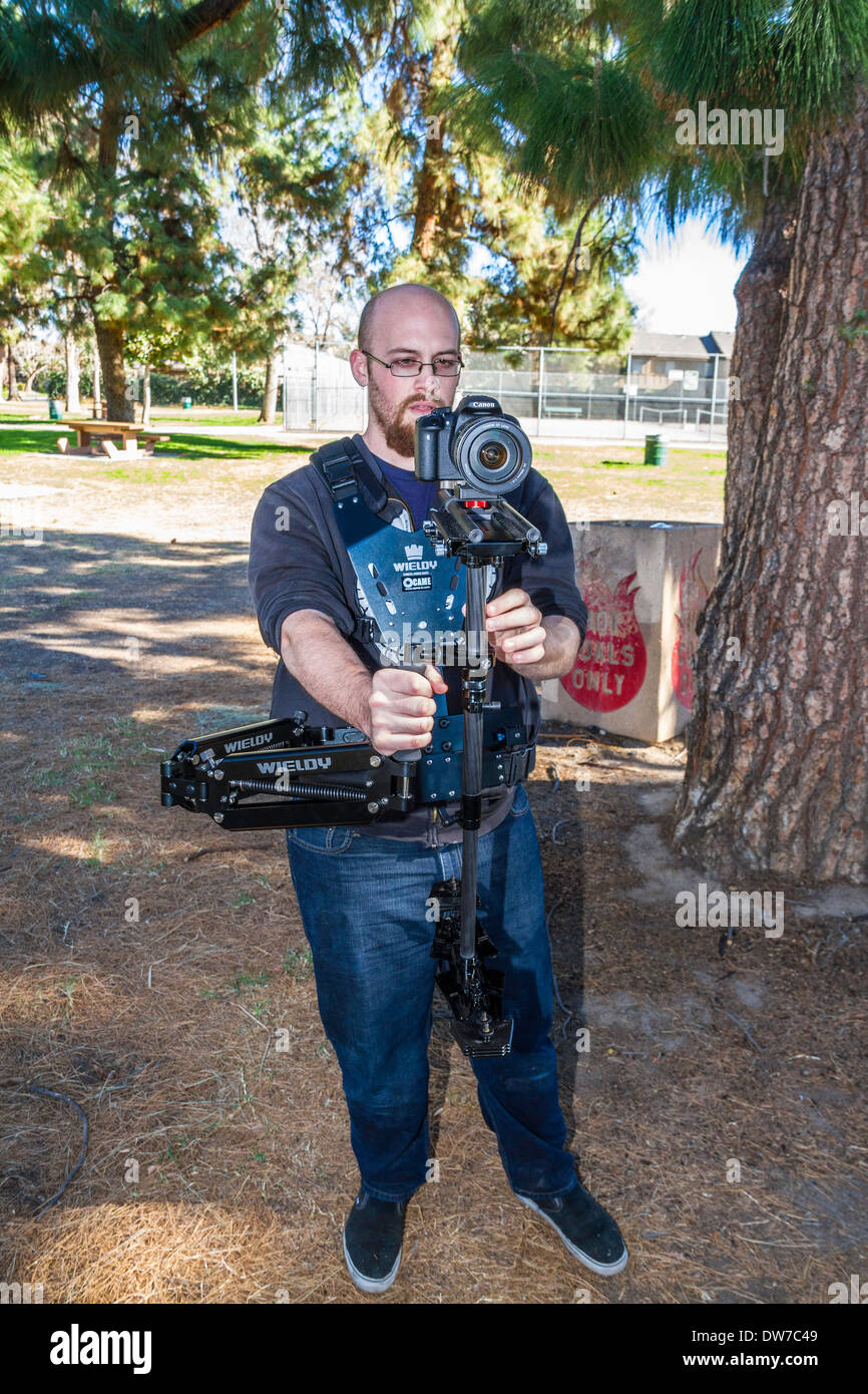 A young man with a DSLR steadycam rig Stock Photo - Alamy