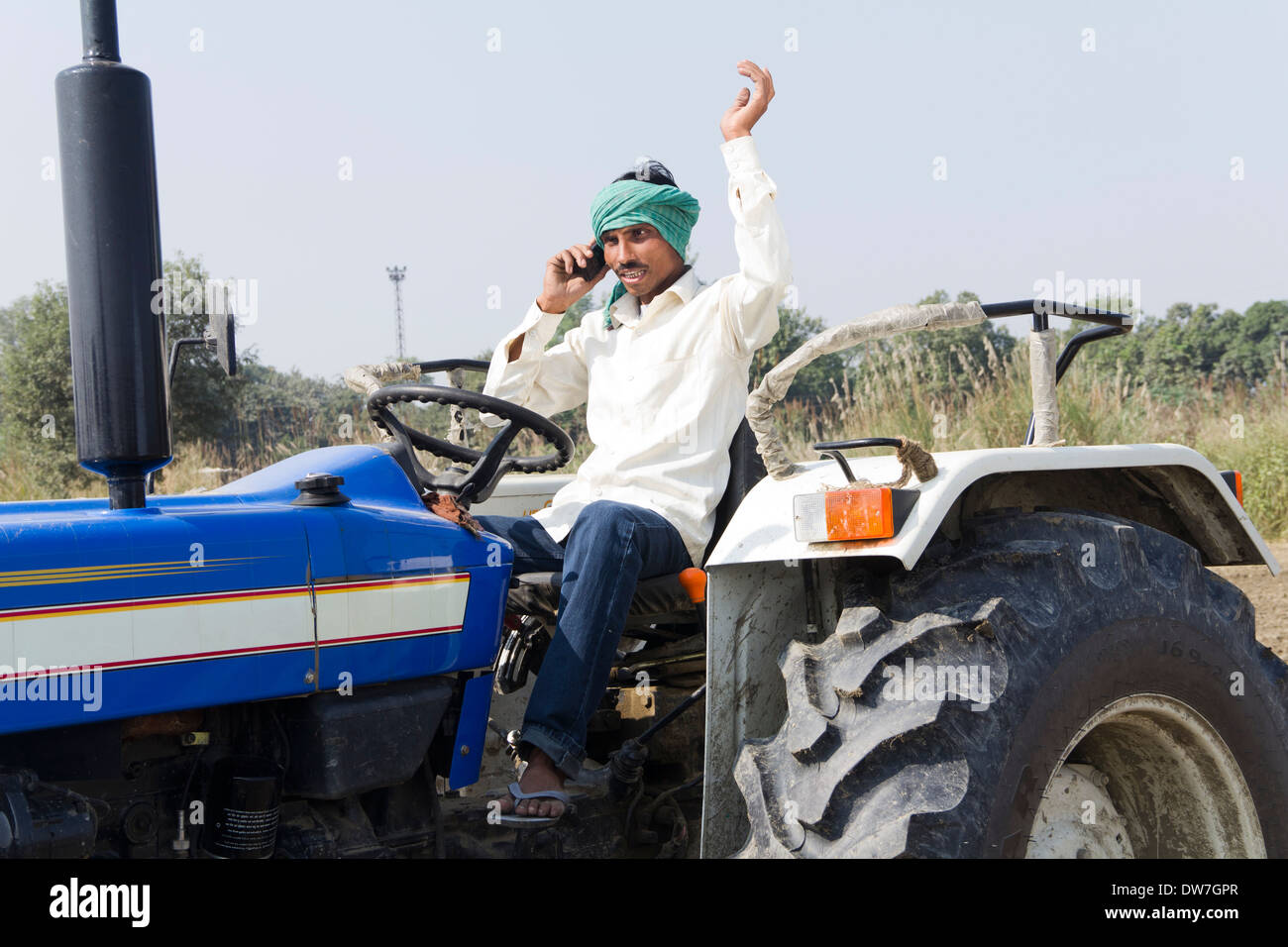 1 indian farmer driving tractor and talking Stock Photo - Alamy