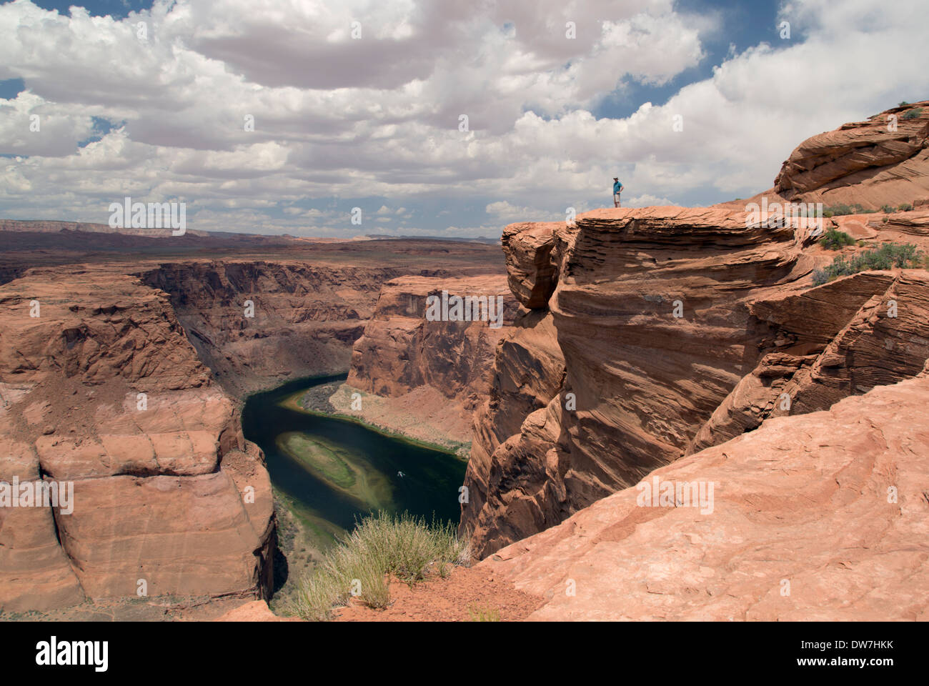 Lone man standing on cliff overlooking Horseshoe Bend in Arizona Stock ...