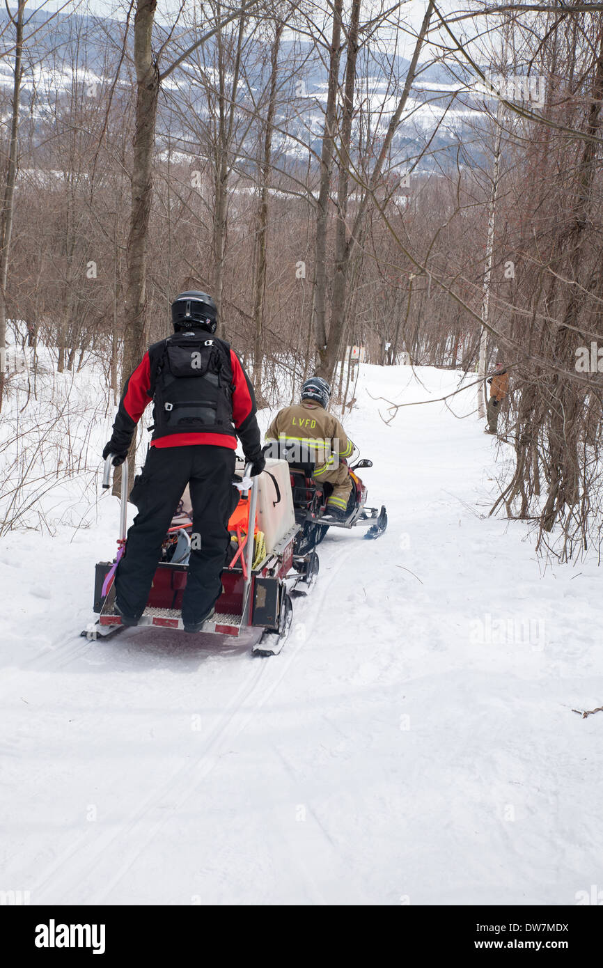 Members of the Thunderbolt Ski Patrol ride a snowmobile and pull sled ...