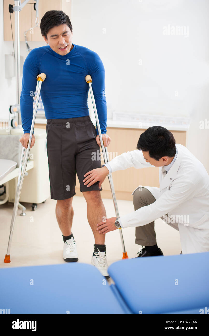 Doctor examining patient's leg Stock Photo - Alamy