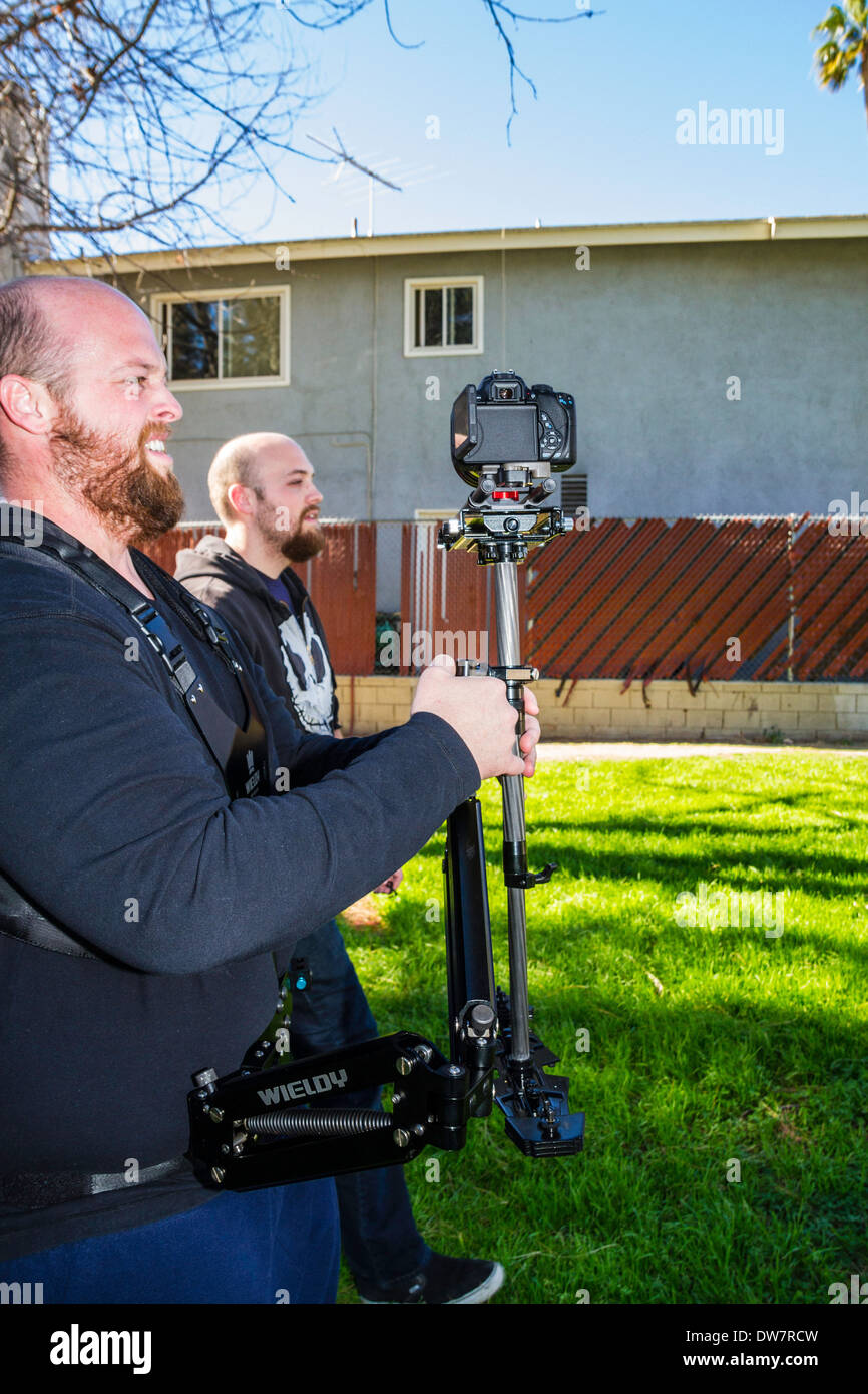 Two young men working with a Steadycam rig for a DSLR Stock Photo - Alamy