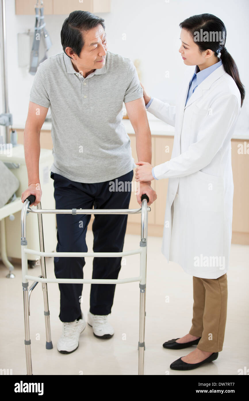 Doctor helping patient with walker Stock Photo - Alamy