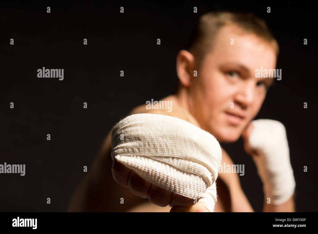 Young boxer throwing a powerful punch in the direction of the camera ...
