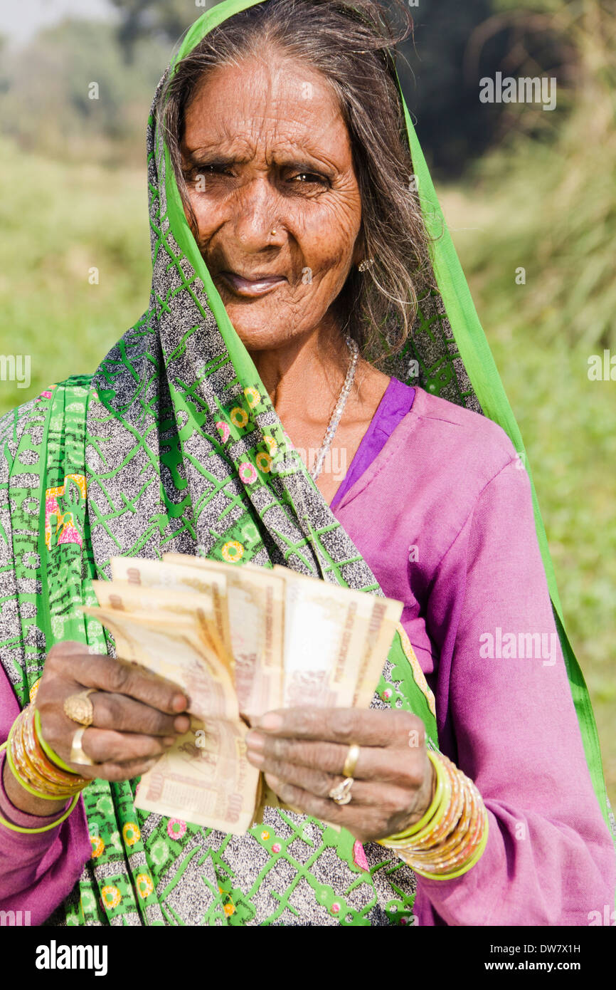 1 Indian woman standing with rupees and counting Stock Photo - Alamy