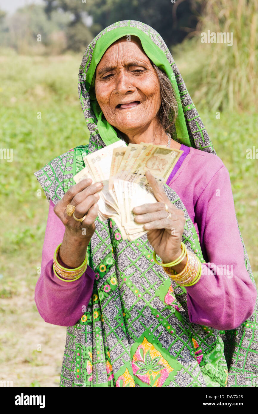 1 Indian woman standing with rupees and counting Stock Photo - Alamy