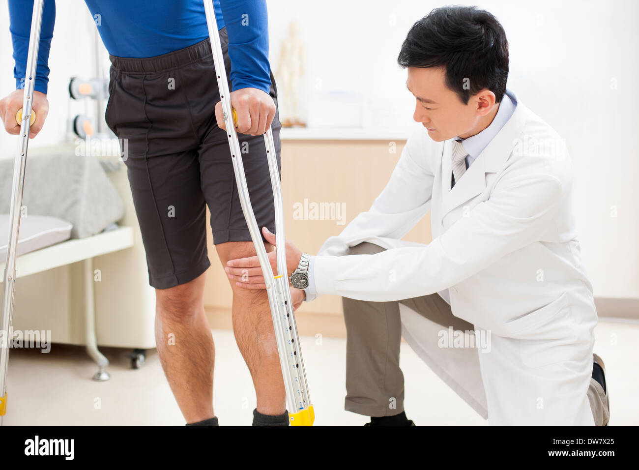 Doctor examining patient's leg Stock Photo - Alamy