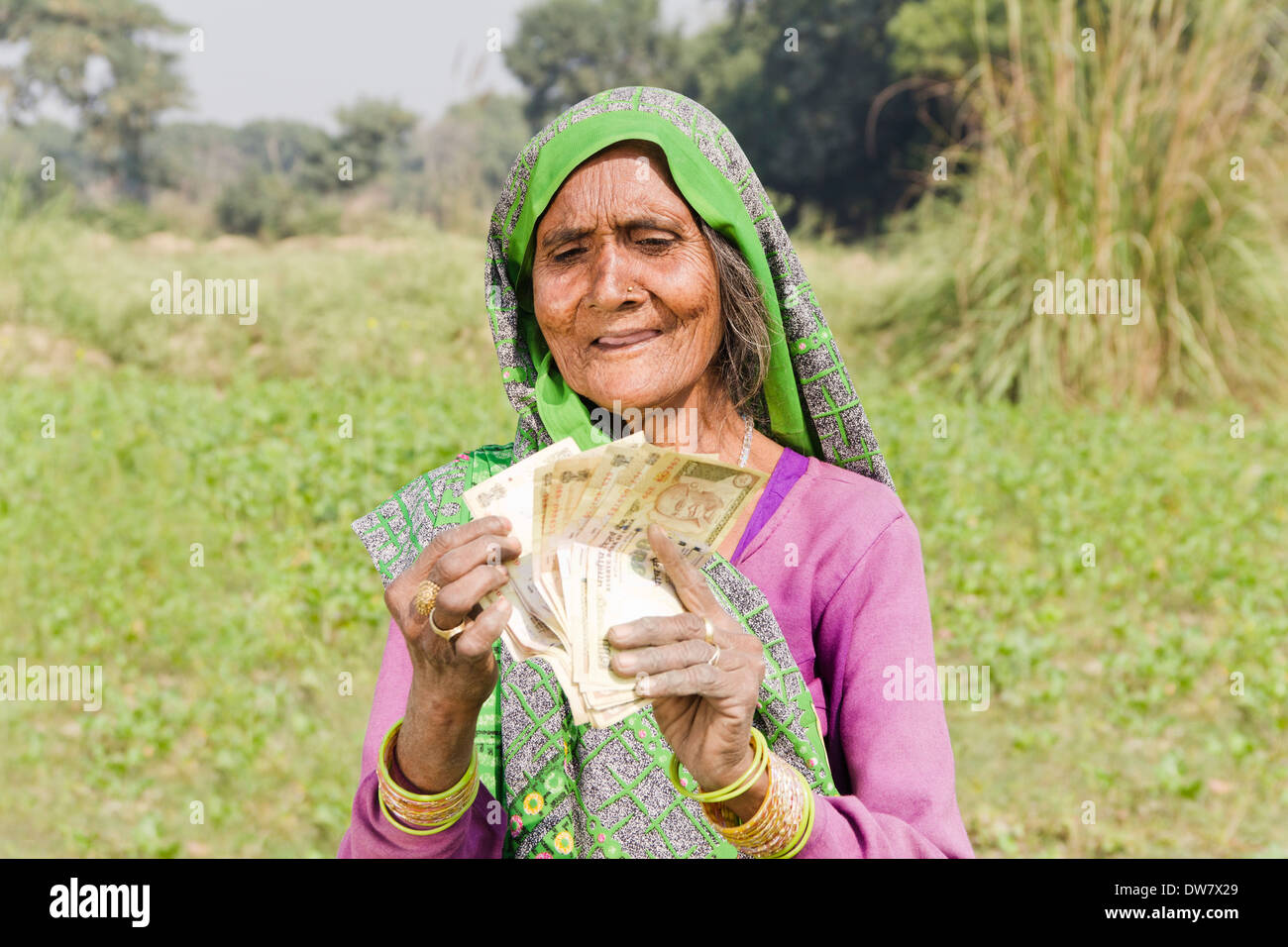 1 Indian woman standing with rupees and counting Stock Photo - Alamy