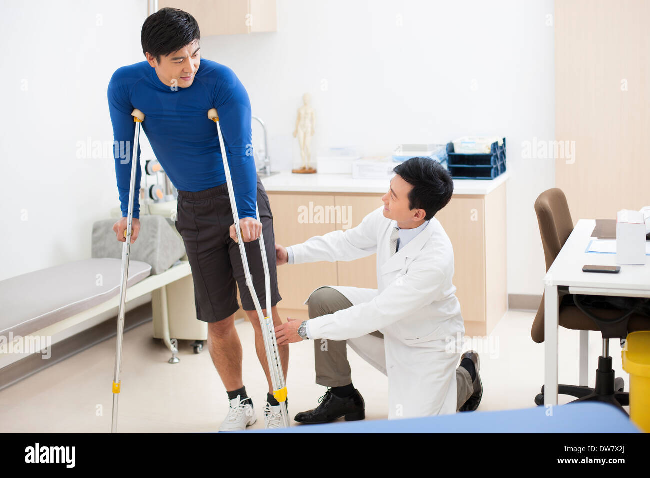 Doctor examining patient's leg Stock Photo - Alamy