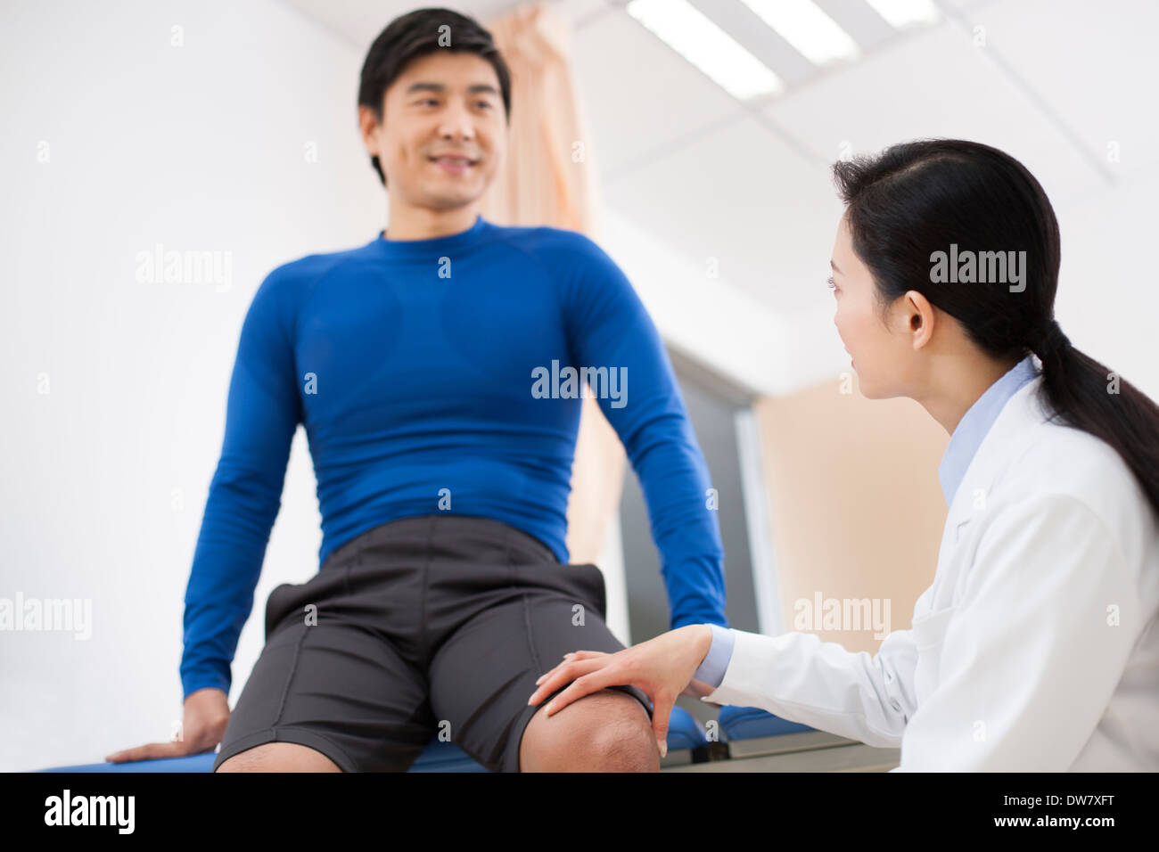 Doctor examining patient's leg Stock Photo - Alamy