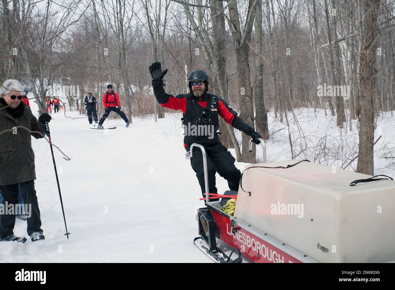 A happy member of the Thunderbolt Ski Patrol waves as his snowmobile ...