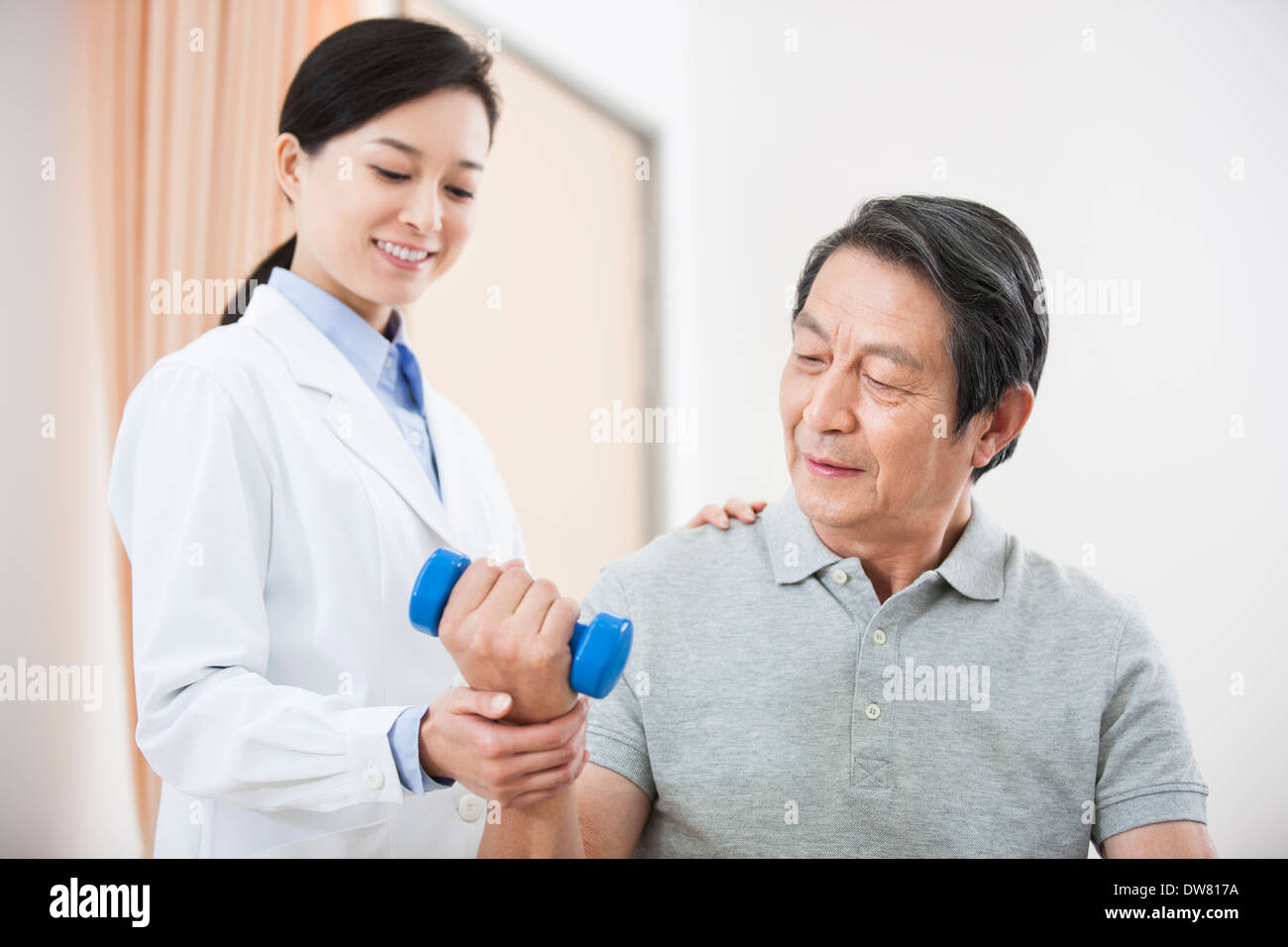Senior patient exercising with dumbbell under doctor's help Stock Photo ...