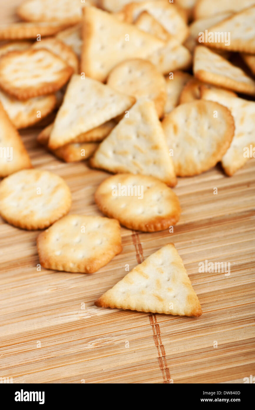 Stack of different shaped salty cracker biscuits on bamboo background ...