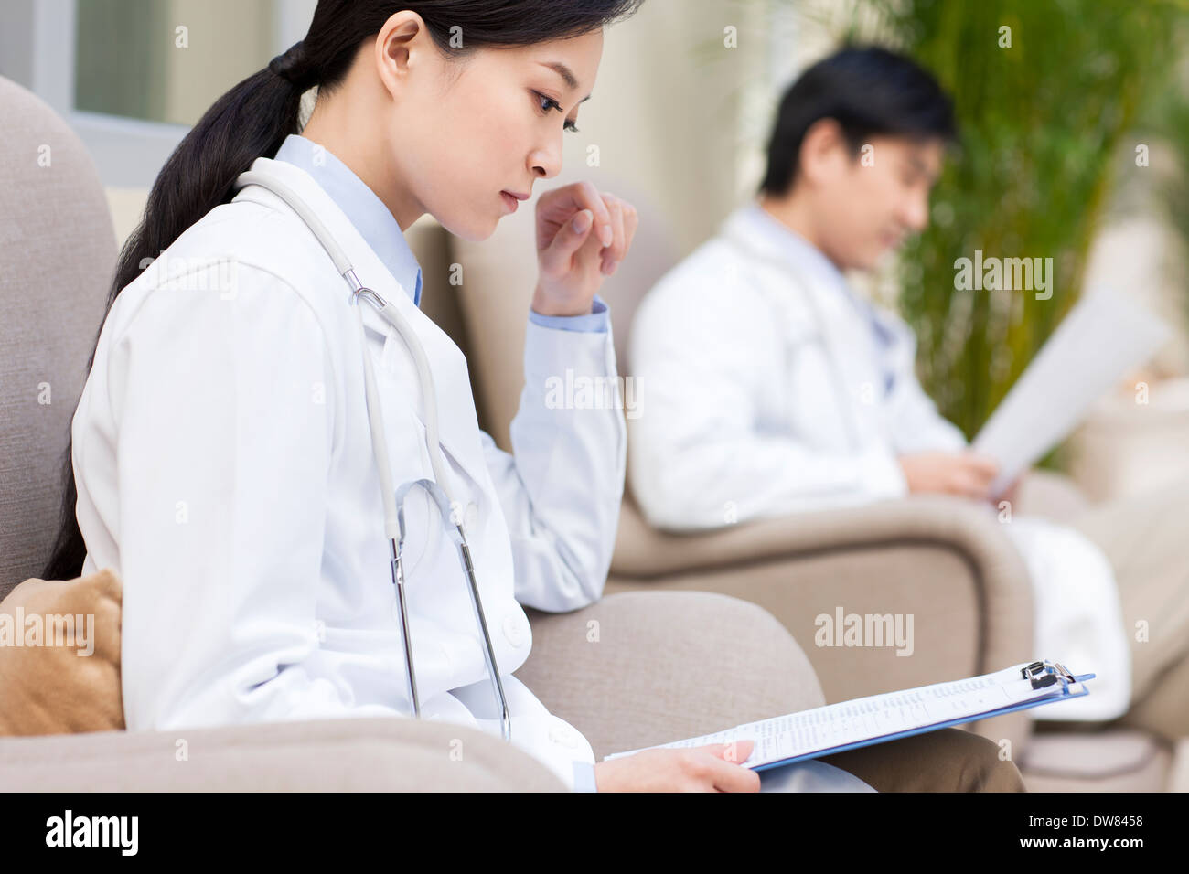Doctors reading files Stock Photo - Alamy
