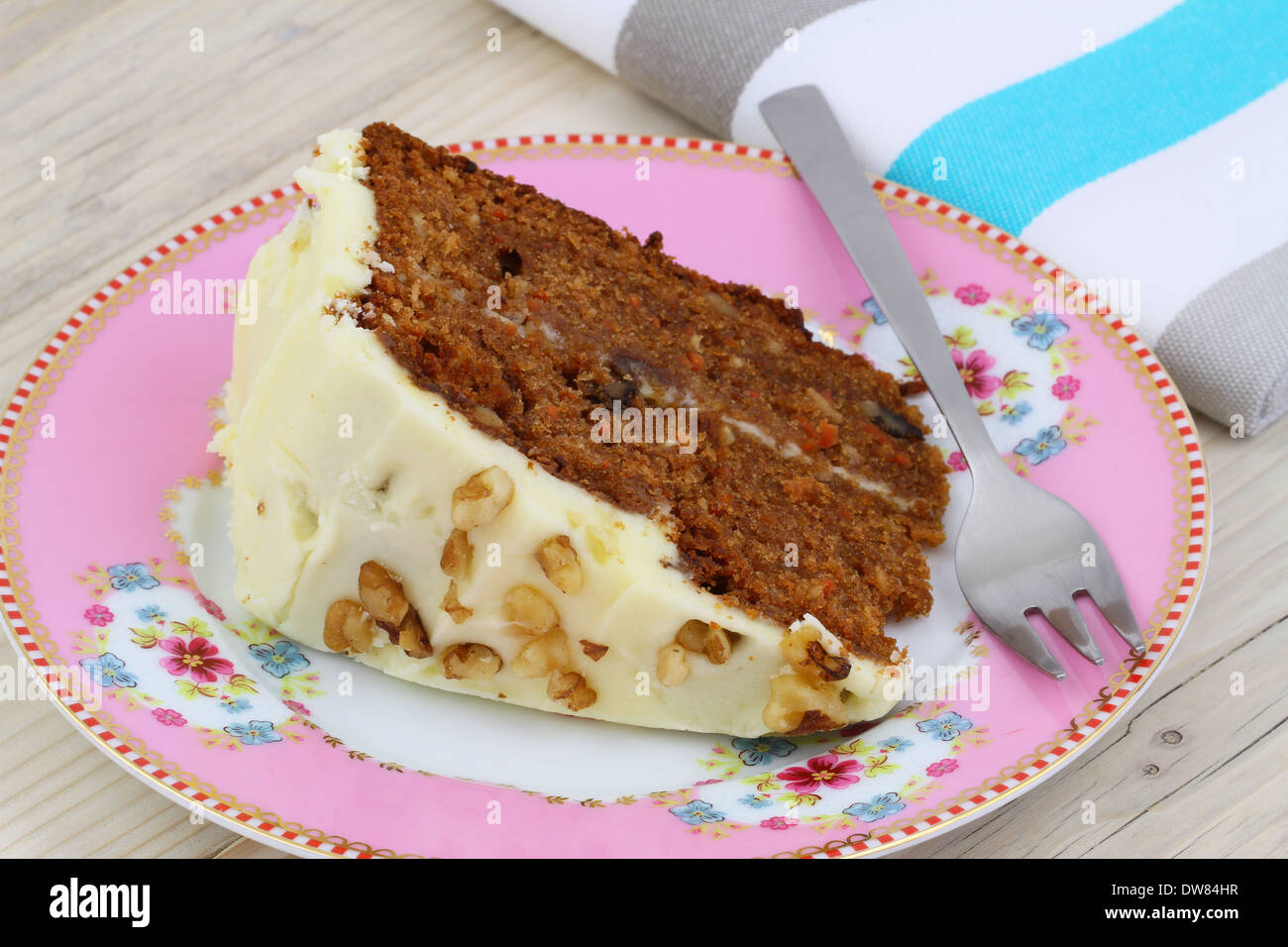 Carrot cake with walnuts and marzipan icing on pink napkin Stock Photo ...
