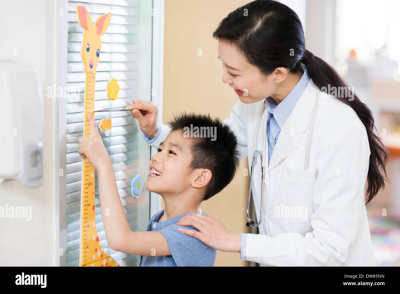 Doctor measuring boy's height Stock Photo - Alamy