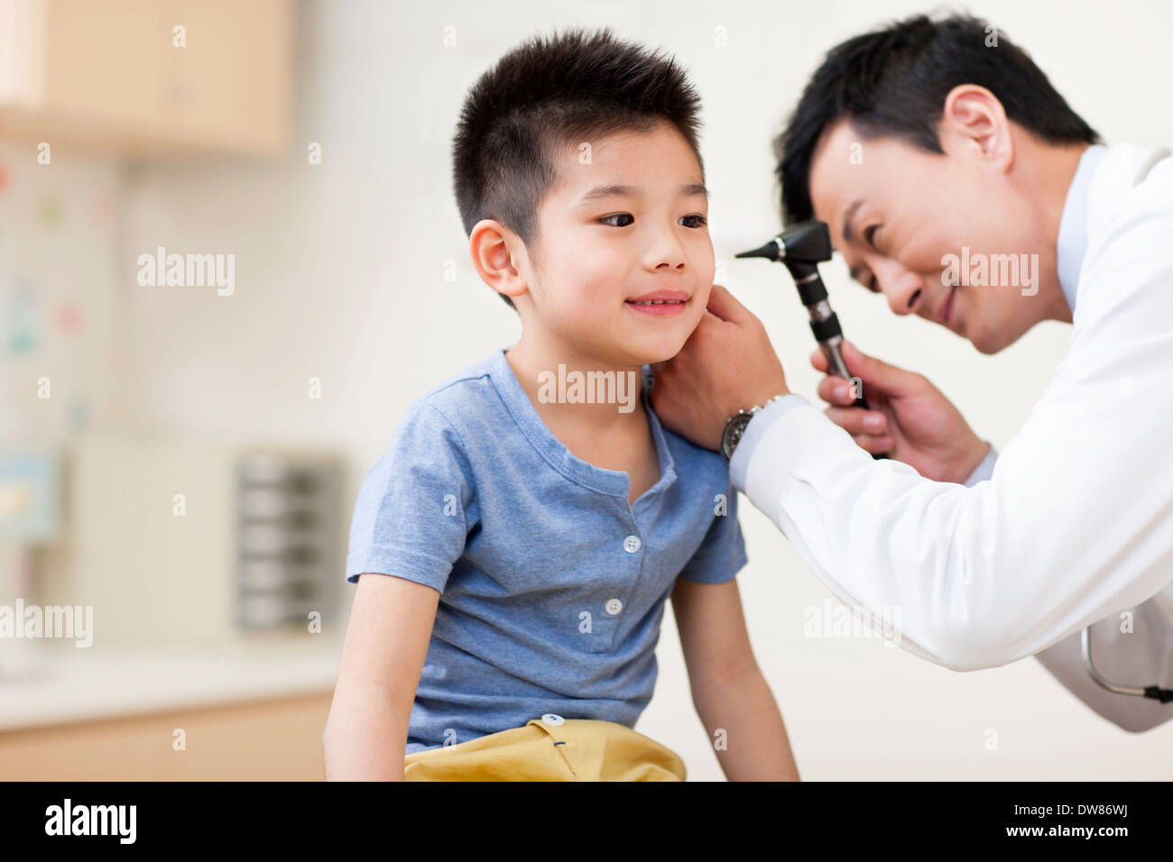 Doctor examining boy's ears Stock Photo - Alamy
