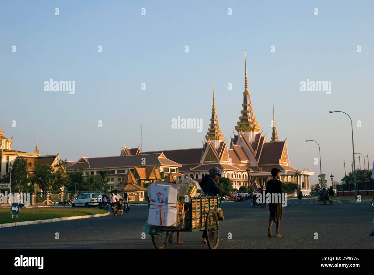 A man is pulling a cart filled with garbage on a city street near a ...