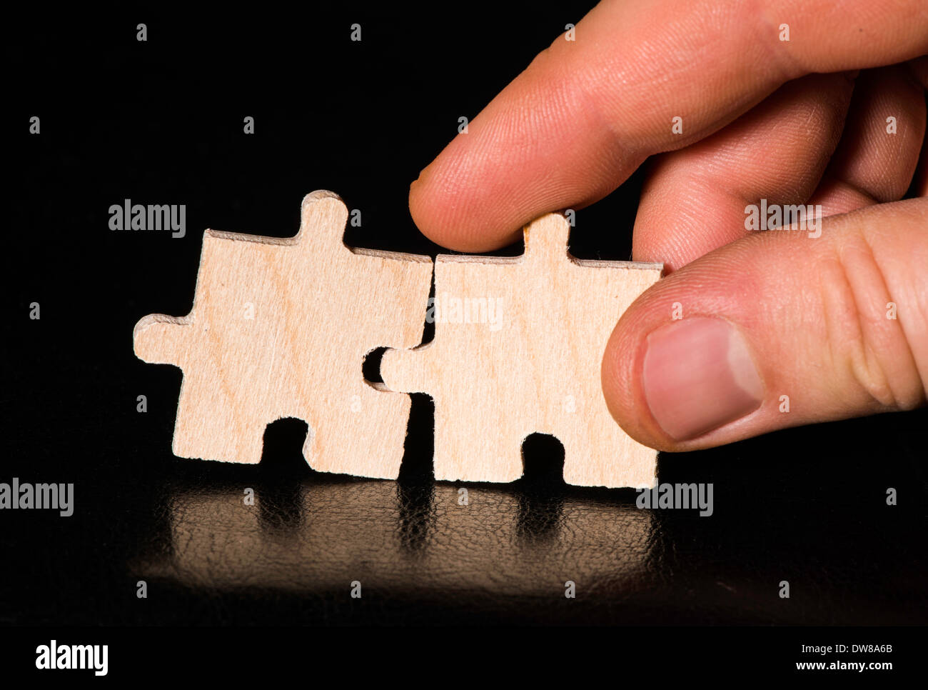 Wooden puzzle on black background. Hand holding puzzle piece Stock ...